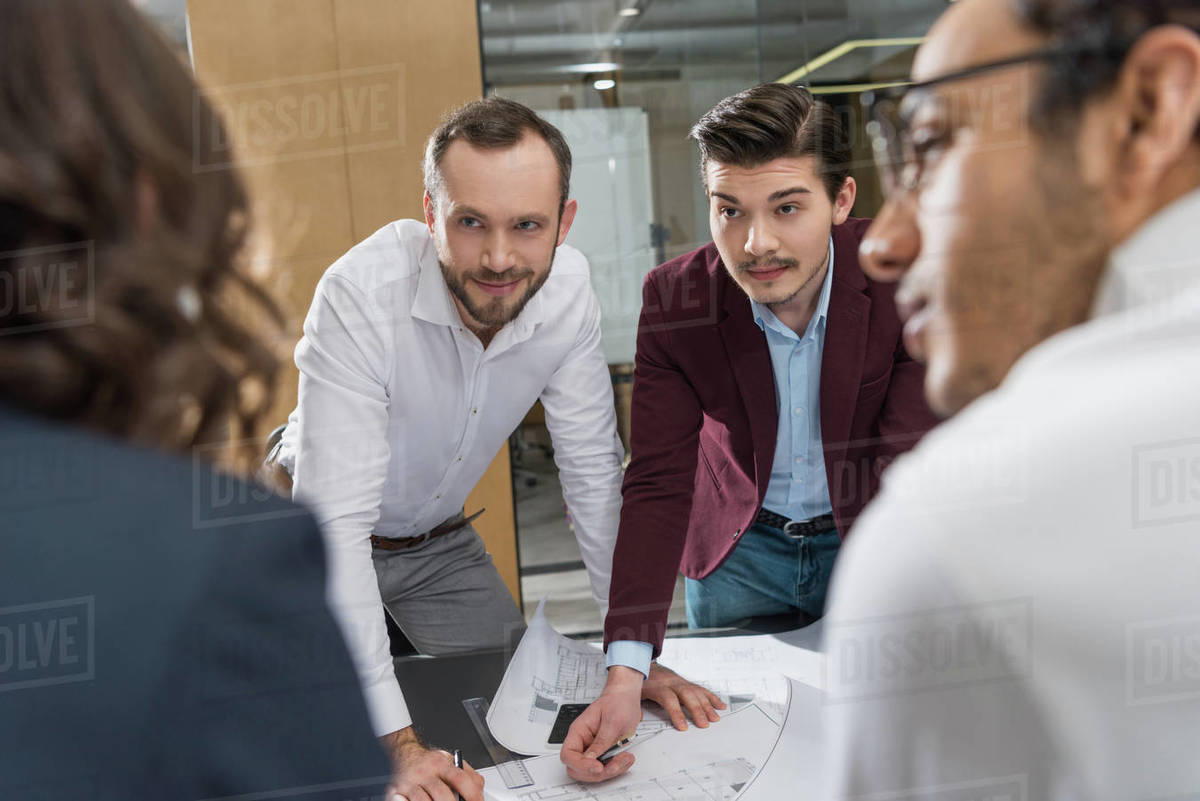 Group of happy architects working together on building plans at office ...