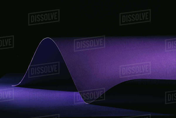 Warping purple paper on purple surface on black - Royalty-free Stock ...