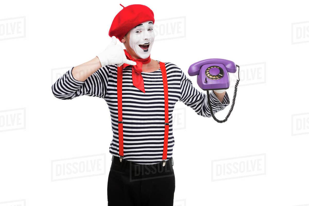 Happy mime holding ultra violet retro stationary telephone and showing ...