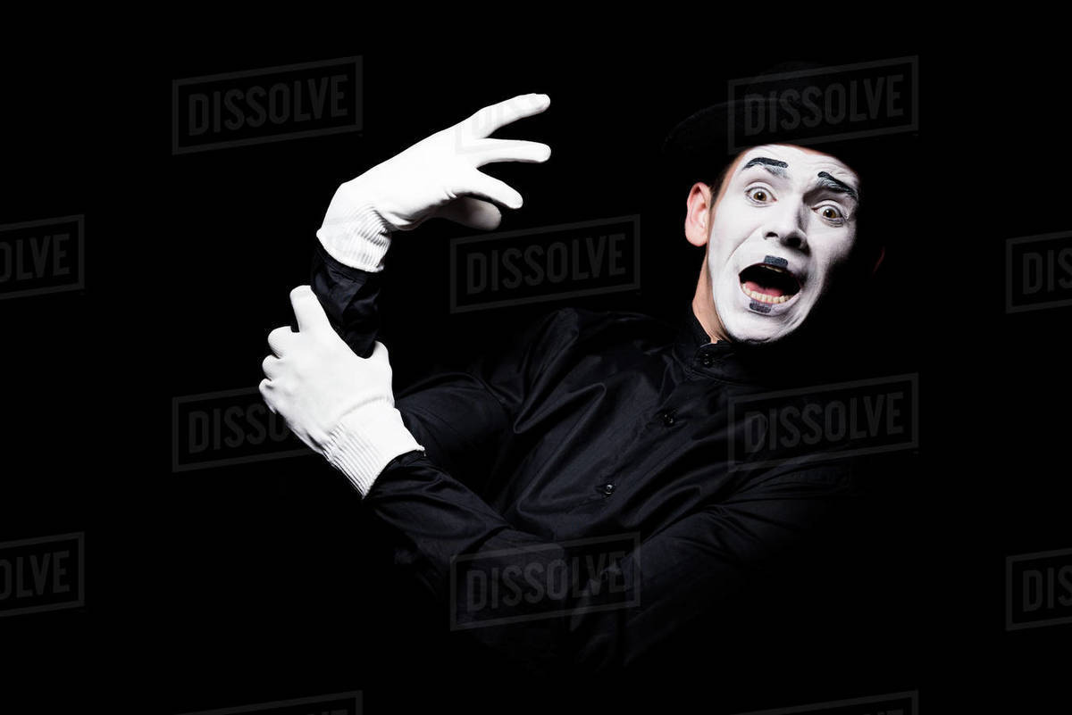 Scared mime with hand monster looking at camera isolated on black ...