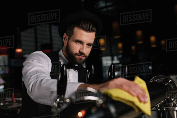 Handsome bartender cleaning beer taps with rag - Royalty-free Stock ...