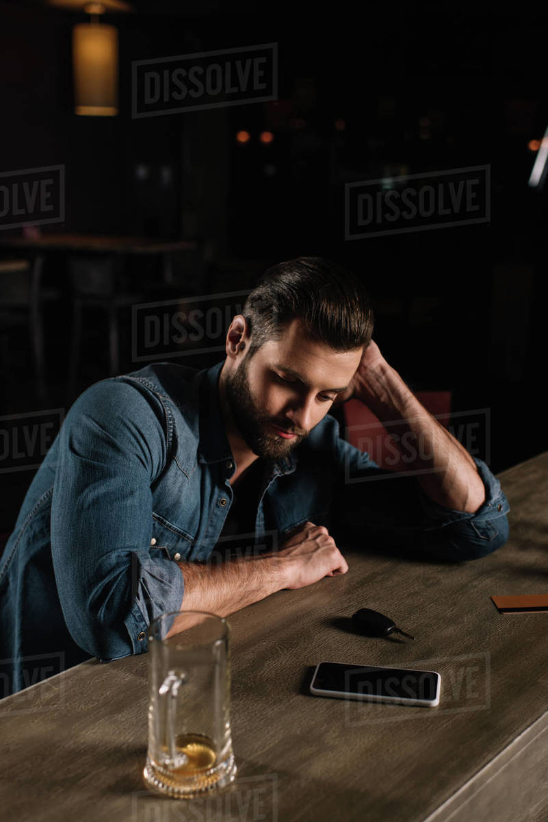 Tired visitor sitting at bar counter in evening - Royalty-free Stock ...