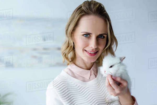 Blonde woman holding white rabbit - Royalty-free Stock Photo | Dissolve