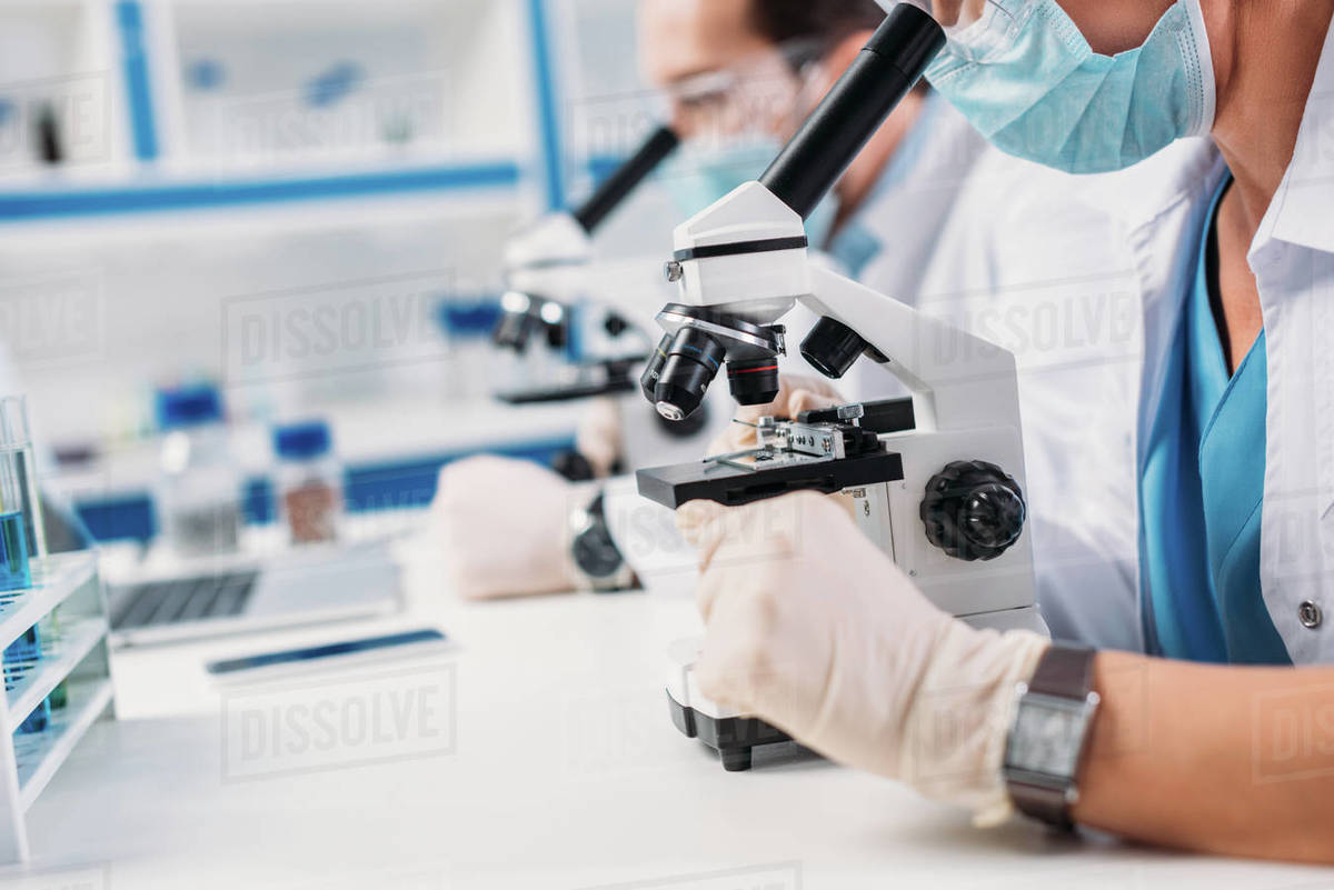 selective focus of scientists in medical masks and goggles looking ...