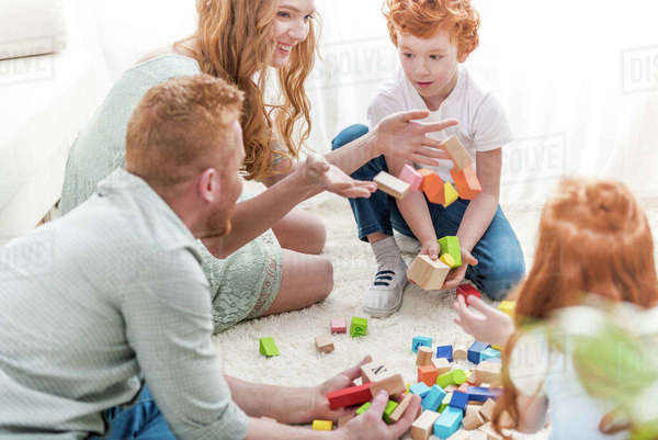 beautiful redhead family playing with constructor on floor at home ...