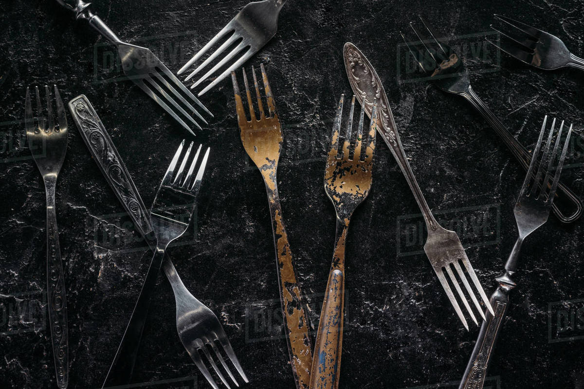 Old metal forks on rusted background - Stock Photo - Dissolve