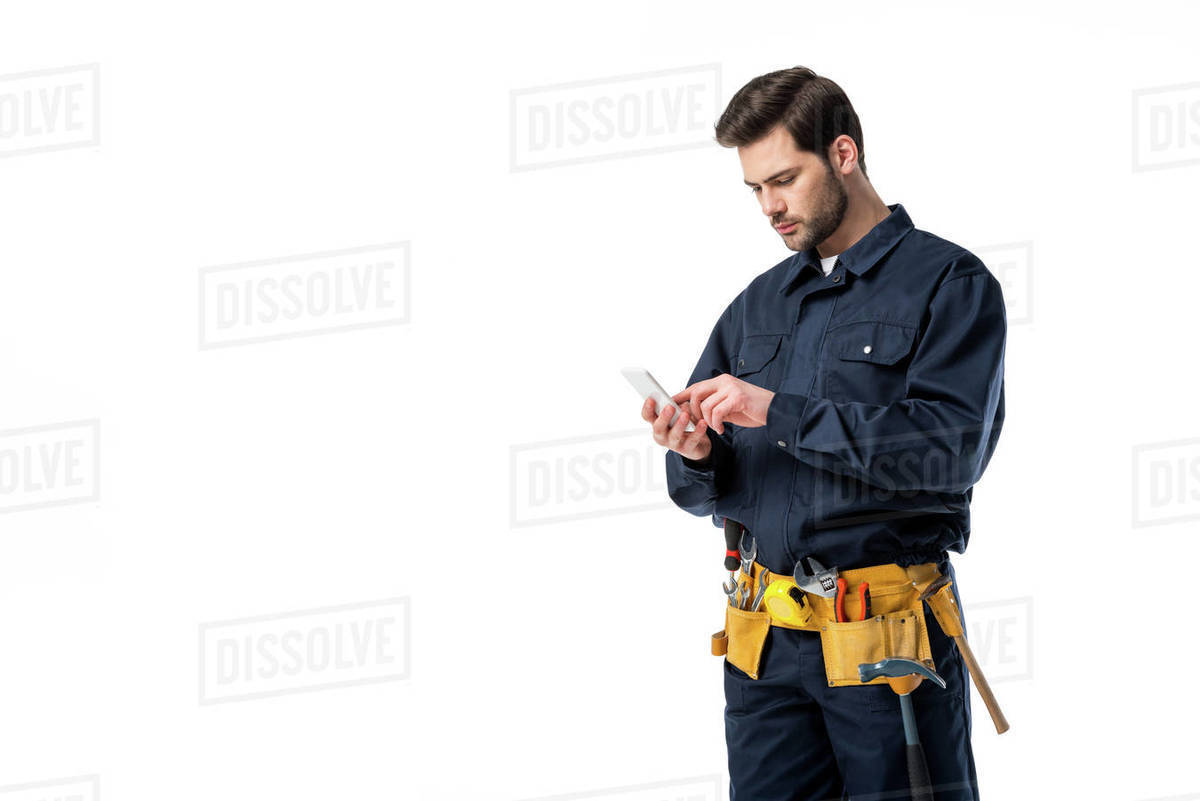 Professional plumber with tool belt using smartphone isolated on white ...