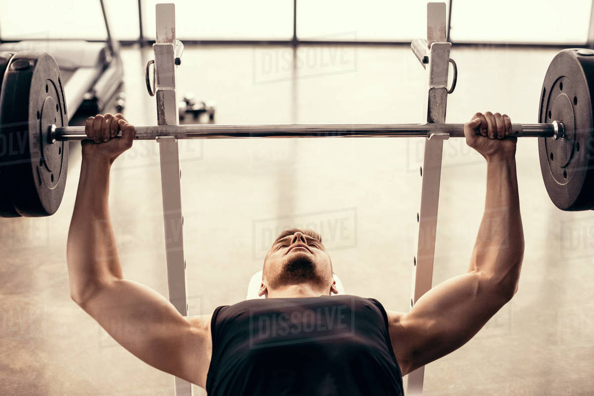 Handsome muscular sportsman lifting barbell in gym - Royalty-free Stock ...
