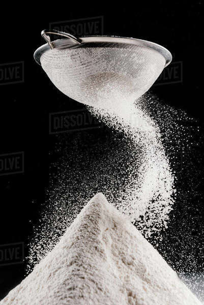 White flour falling from sieve on pile isolated on black - Royalty-free ...
