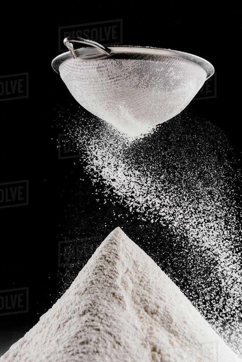 Flour falling from sieve on pile isolated on black - Royalty-free Stock ...