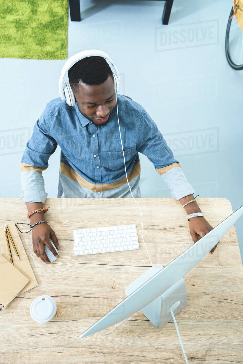 African American man working by computer table - Stock Photo - Dissolve