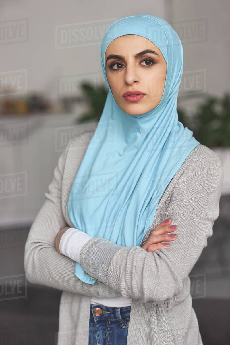 Beautiful serious muslim woman in hijab standing with crossed arms and ...