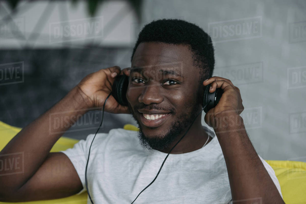 Handsome African American Man Listening Music In Headphones And Smiling