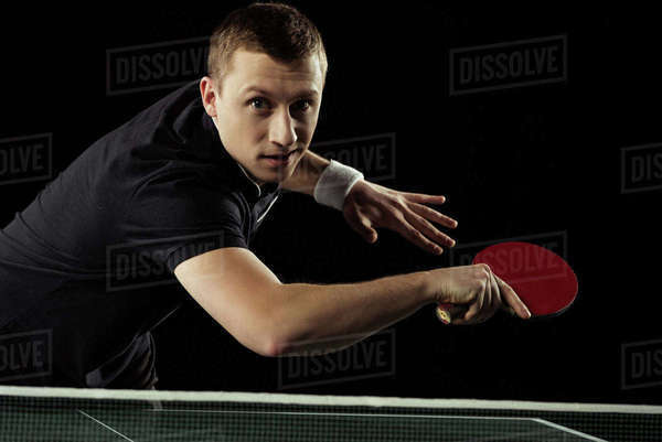 Portrait of focused tennis player playing table tennis isolated on ...