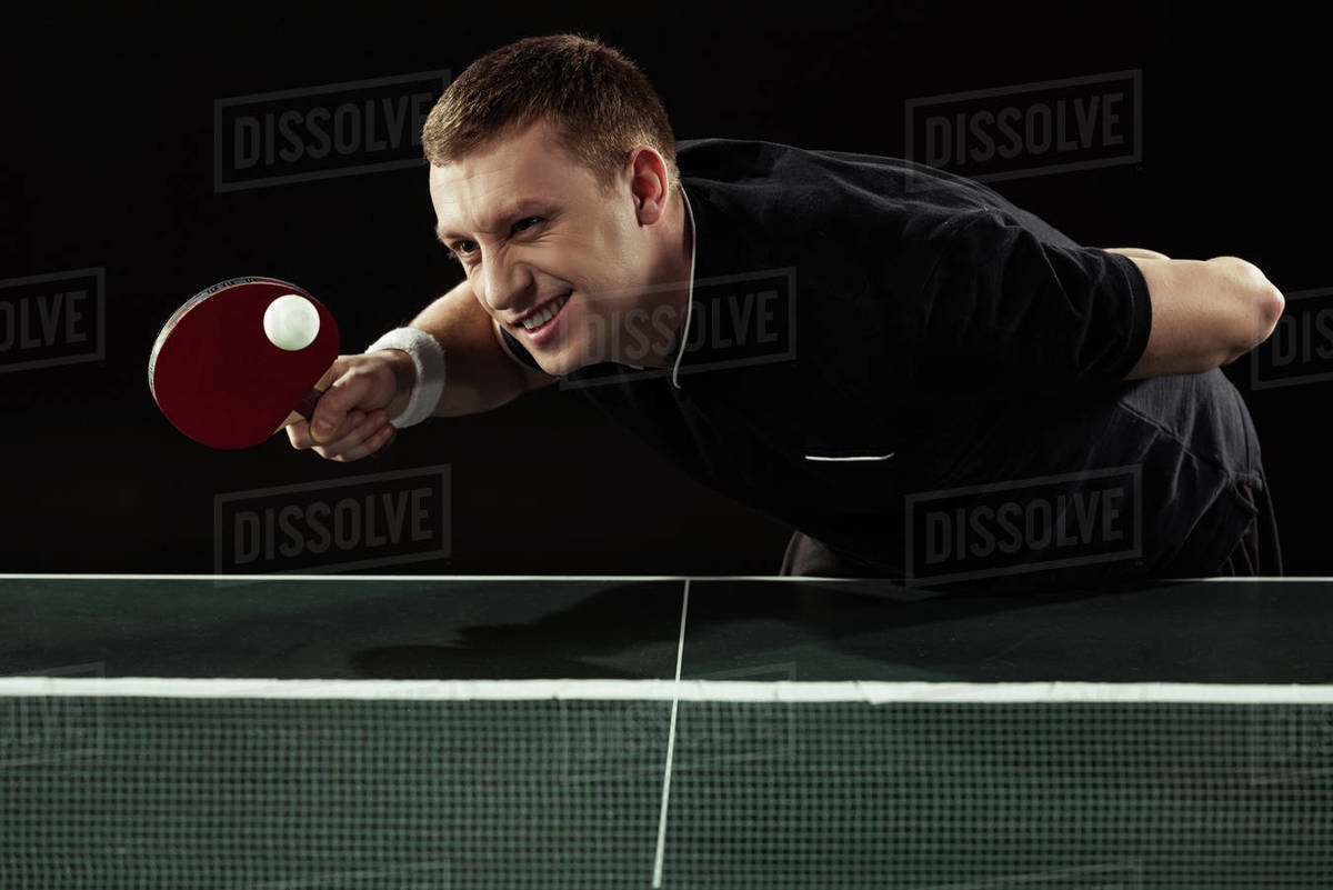 Portrait of emotional tennis player playing table tennis isolated on ...