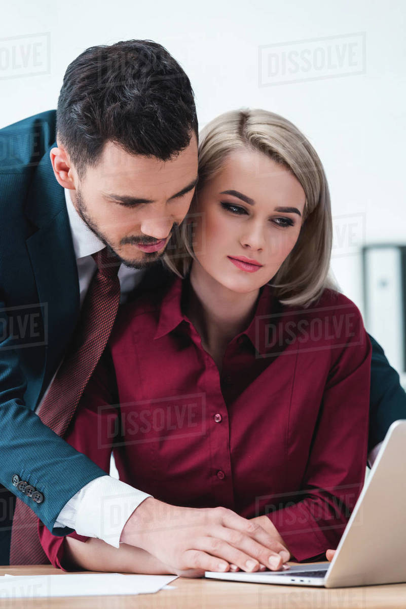 handsome businessman flirting with beautiful female colleague using ...