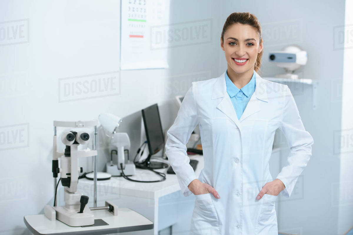 Smiling female optometrist posing in optical clinic - Stock Photo ...