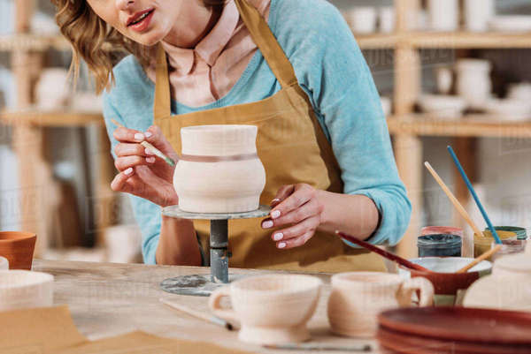 Cropped view of woman painting ceramic jug in pottery workshop - Stock ...