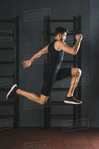 Side view of young jumping sportsman in gym - Royalty-free Stock Photo ...