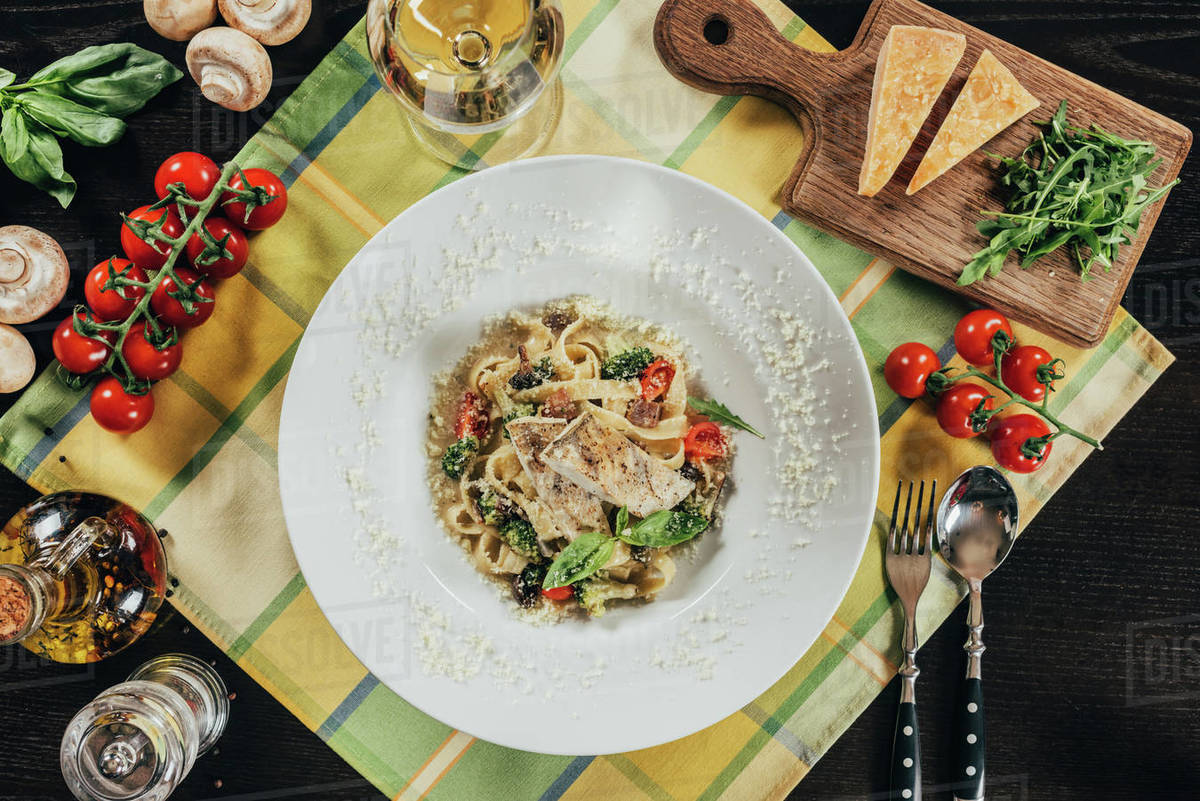 Top view of pasta with pike perch fillet and grilled vegetables on ...