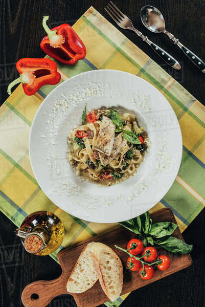 Top view of pasta with pike perch fillet and grilled vegetables on ...