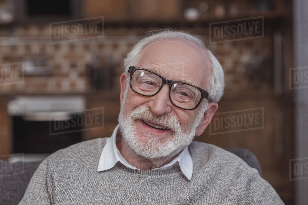 Portrait of smiling grey hair man looking at camera at home - Royalty ...