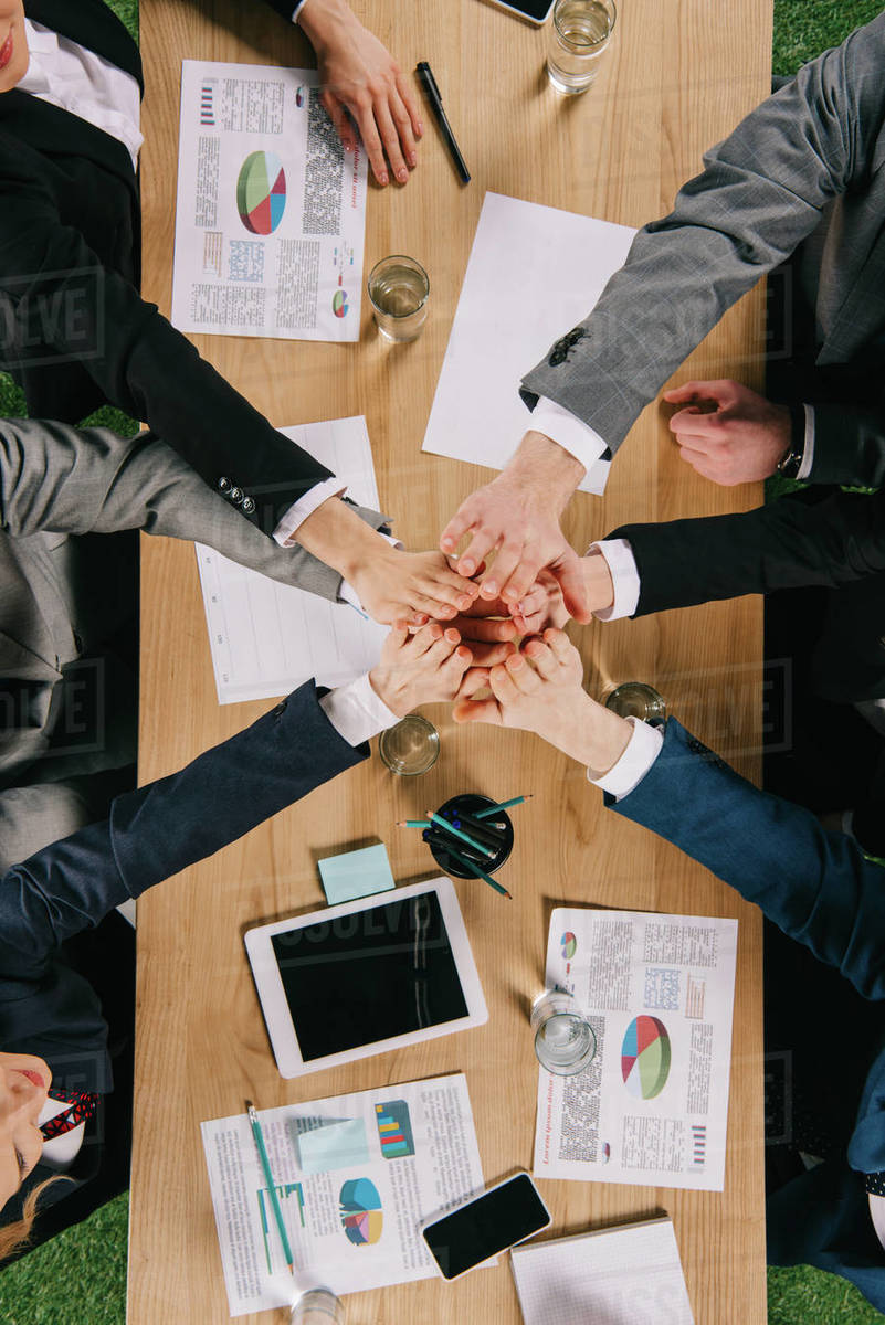 Cropped view of business partners at table in office, businesspeople ...