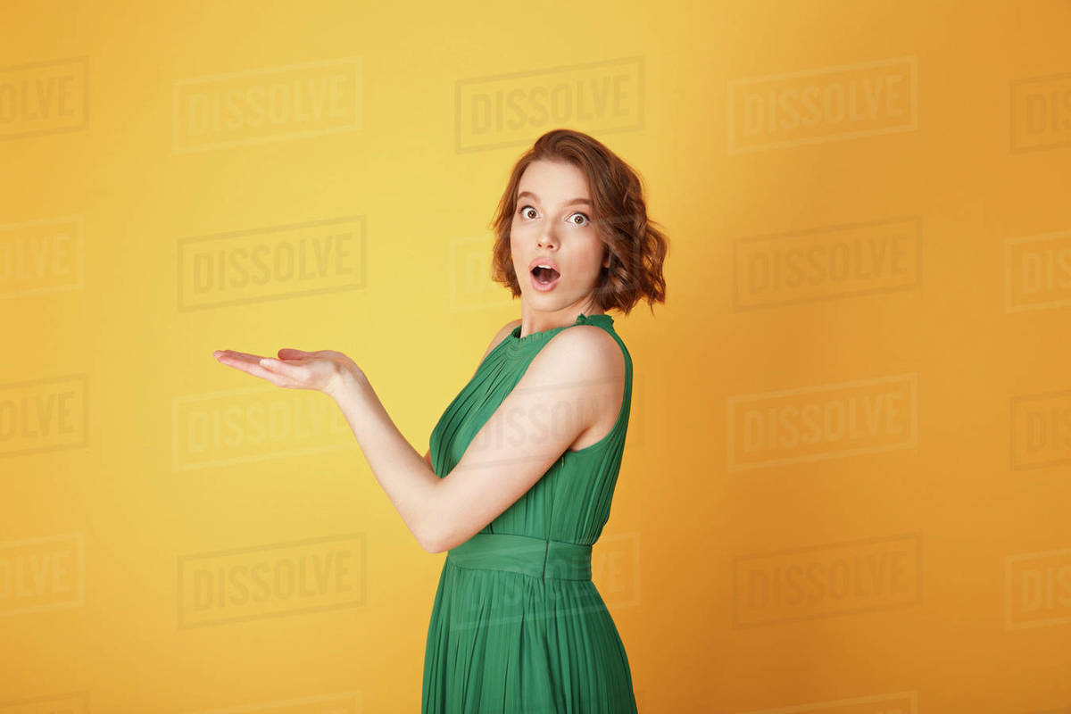 Side view of shocked woman with outstretched arms looking at camera ...