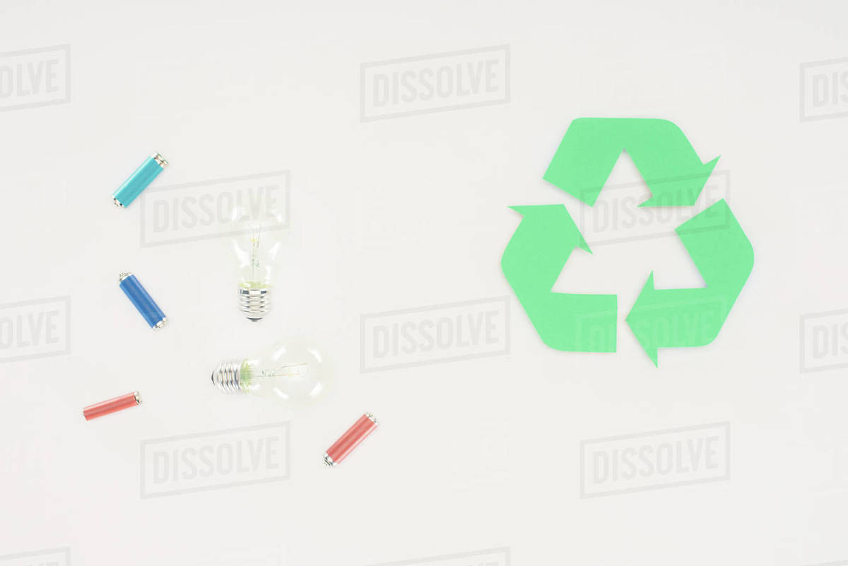 Top view of light bulbs and batteries with recycle sign on white ...