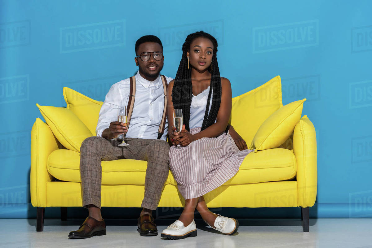 Beautiful young African American couple holding wine glasses and ...