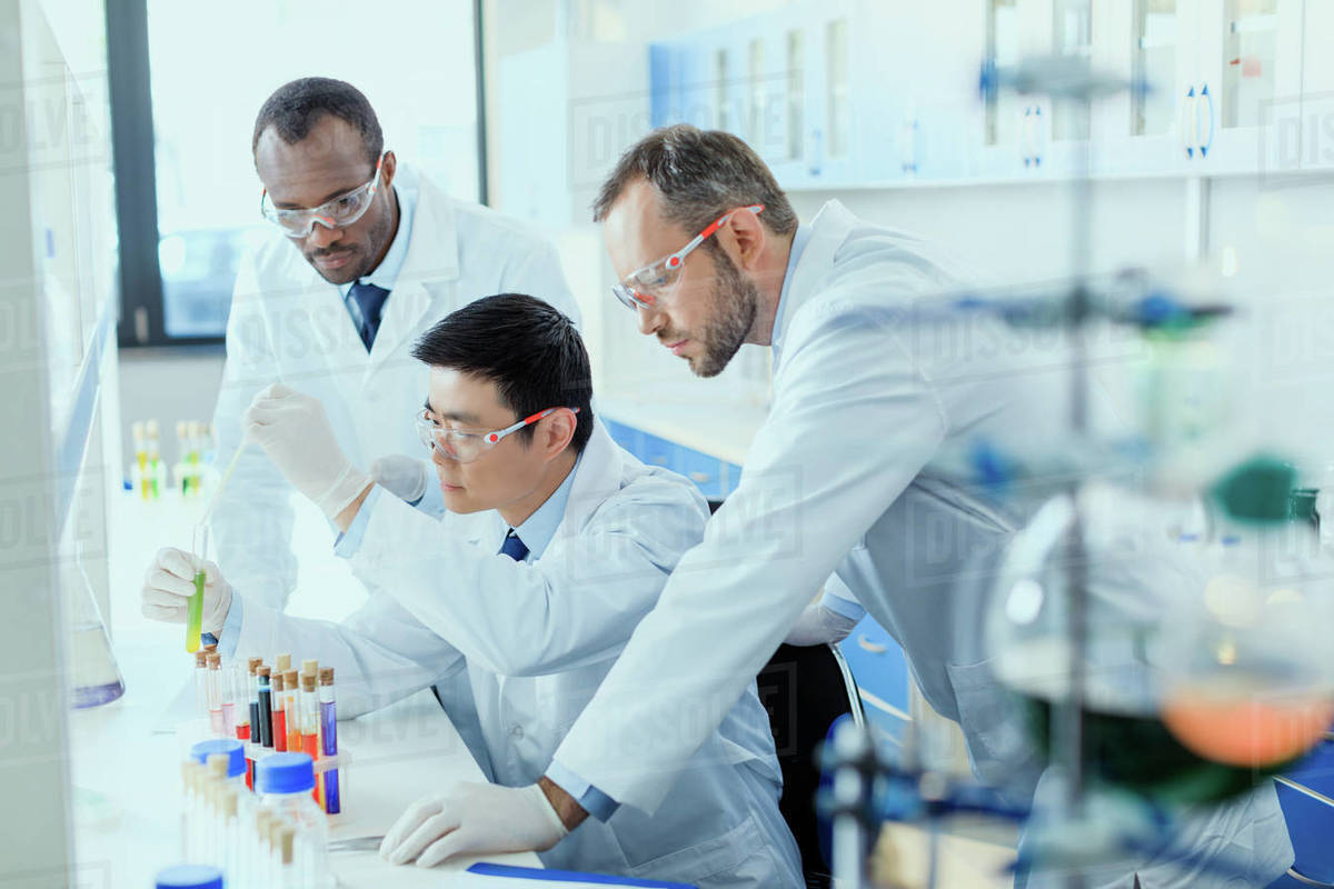 Professional scientists in white coats working together in chemical ...
