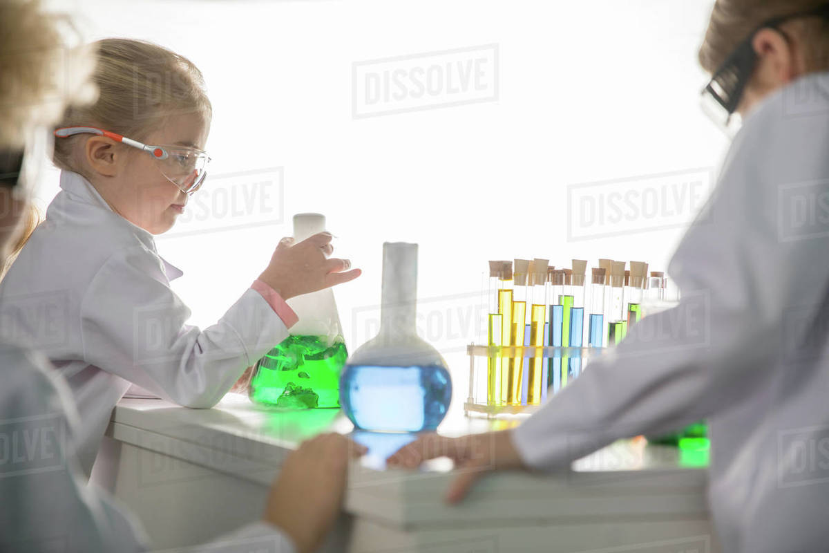 Schoolchildren making experiment with test tubes and flasks in chemical ...