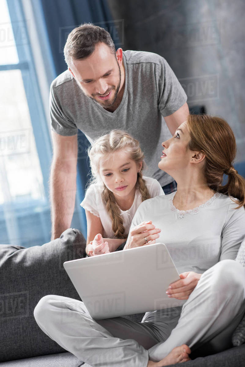 Young family using laptop together at home - Royalty-free Stock Photo ...