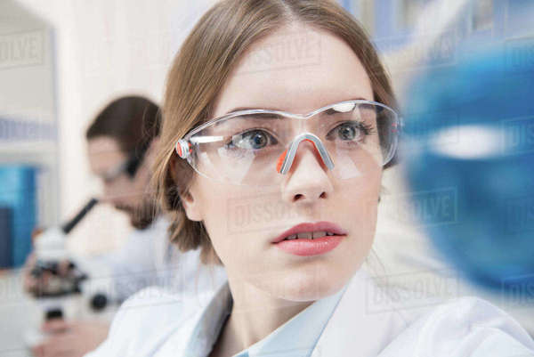 Portrait of attractive young female scientist in protective glasses ...