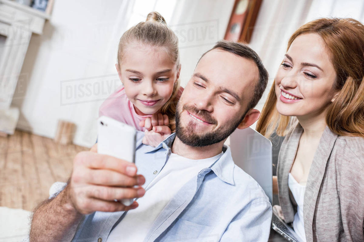 Portrait of happy family using smartphone at home - Royalty-free Stock ...