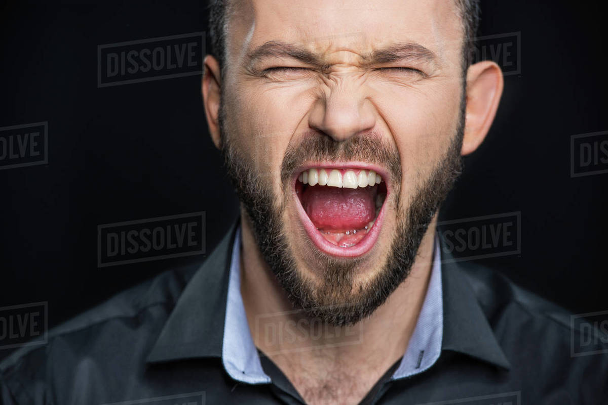 Close-up portrait of bearded man screaming isolated on black - Royalty ...