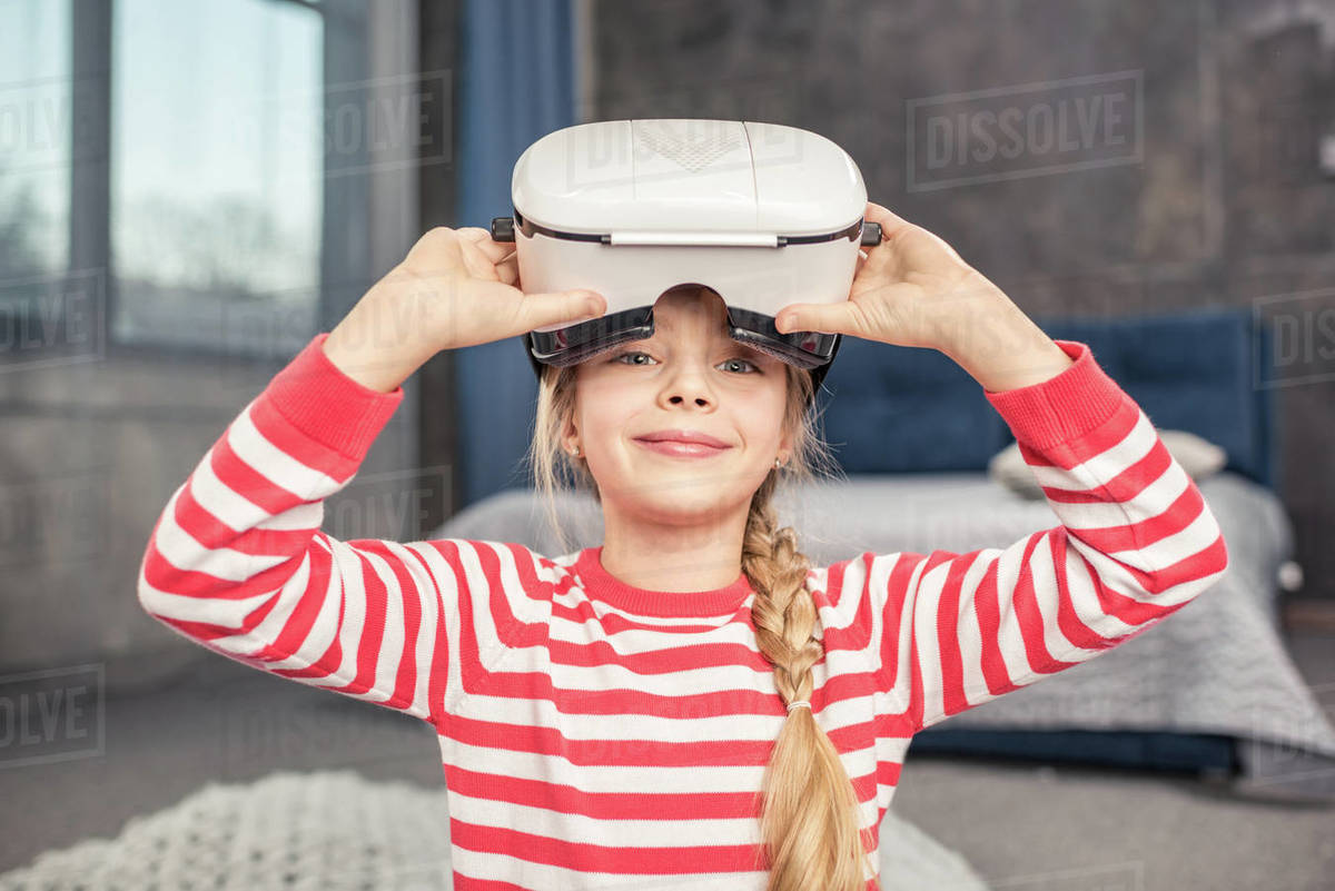 Smiling cute girl wearing virtual reality headset at home - Royalty ...