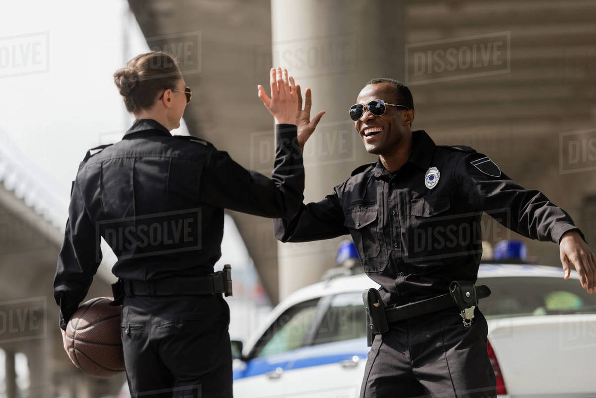 Police officers with basketball ball giving high five - Stock Photo ...