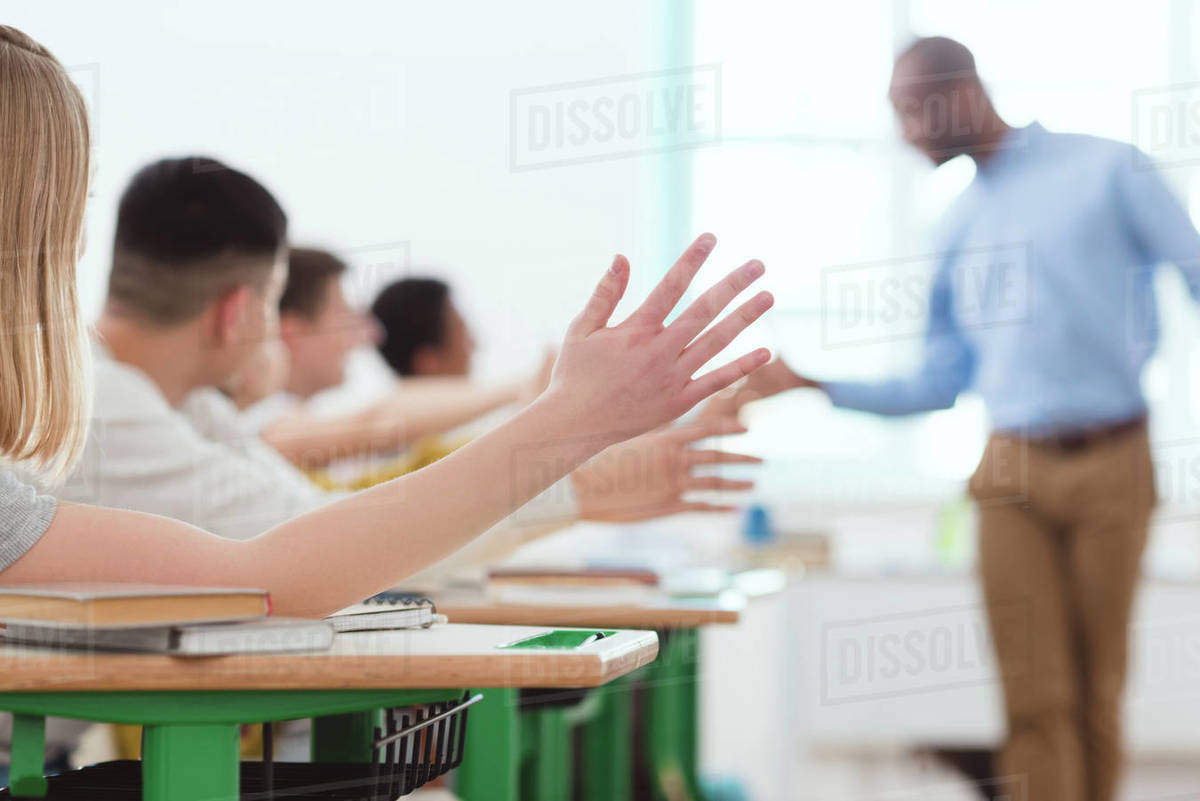 Teacher giving high five to multicultural group of high school teenage ...