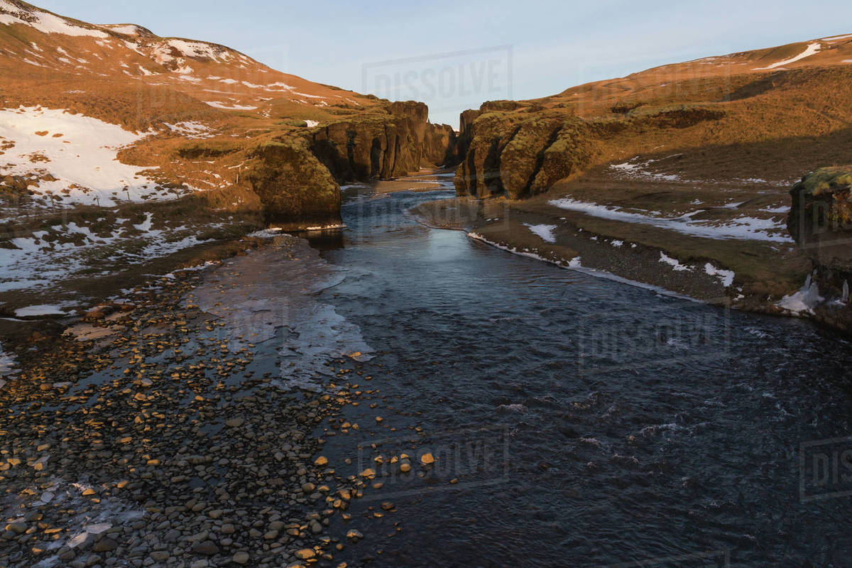 Beautiful Icelandic landscape with cold river, rocks and snow ...