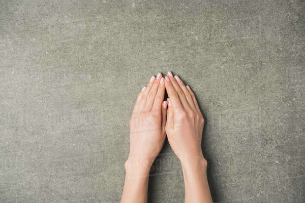 Cropped shot of female hands on grey concrete surface - Royalty-free ...