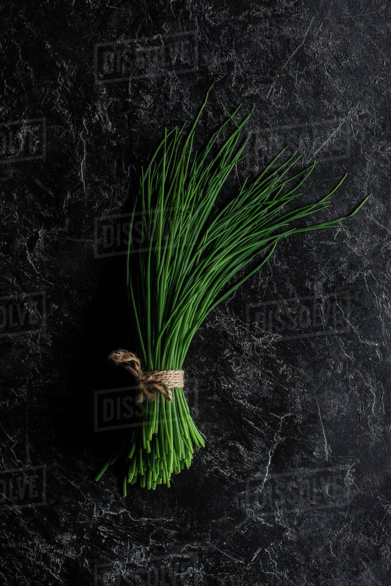 Top view of bunch of chives on concrete table, healthy eating concept ...