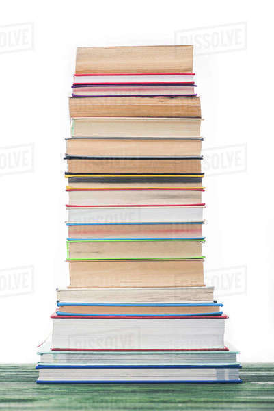 High tower of stacked books on table - Stock Photo - Dissolve