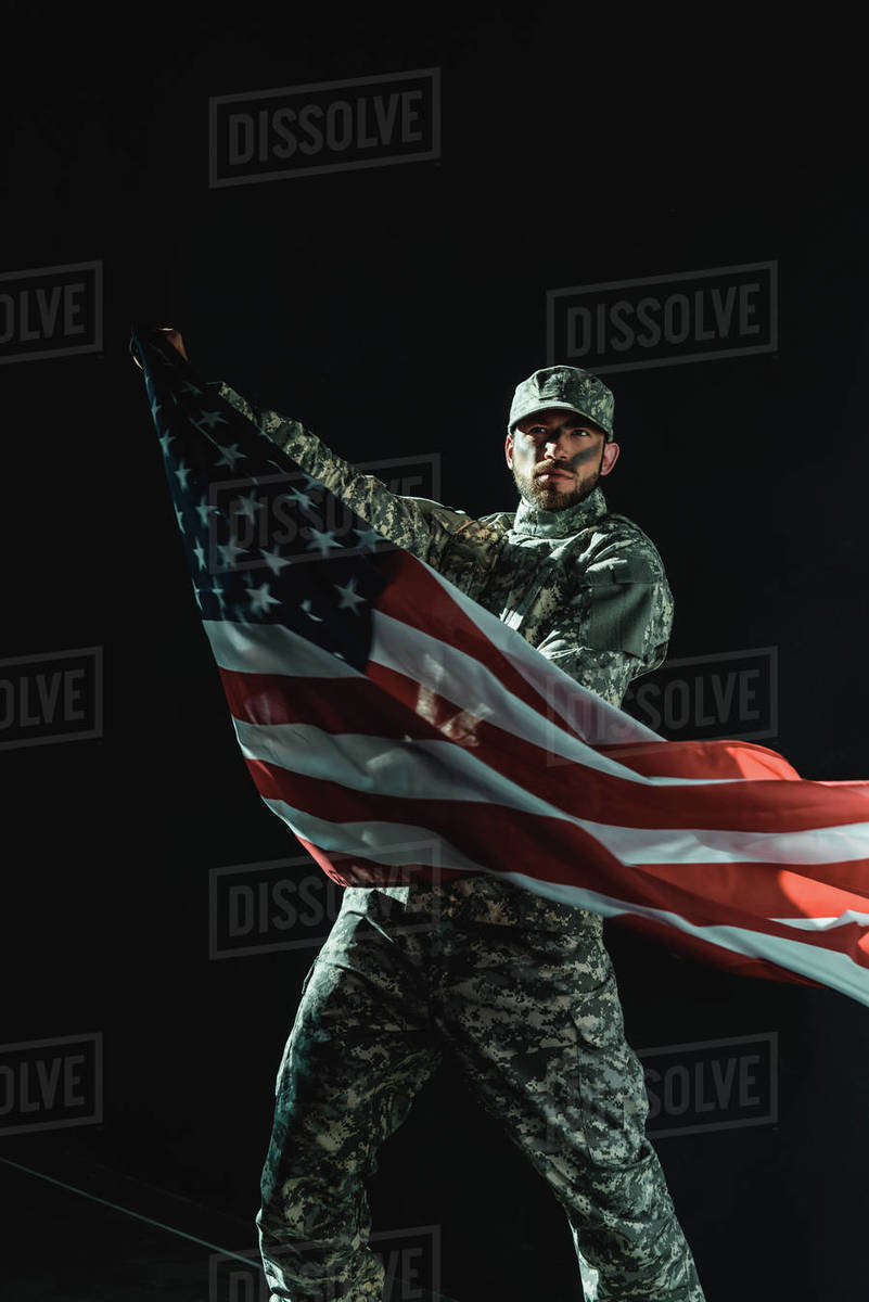 handsome soldier waving united states flag isolated on black - Royalty ...