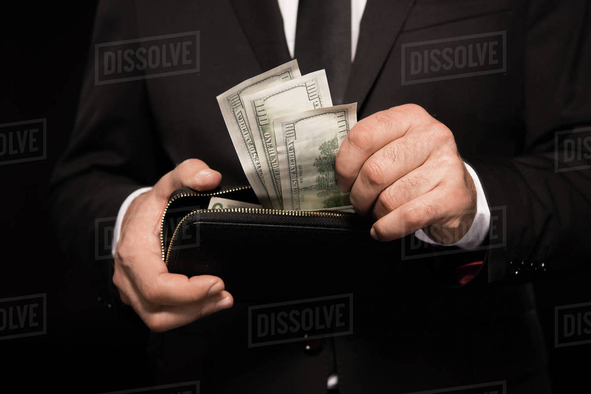 Cropped shot of a man in a business suit taking out money from the ...