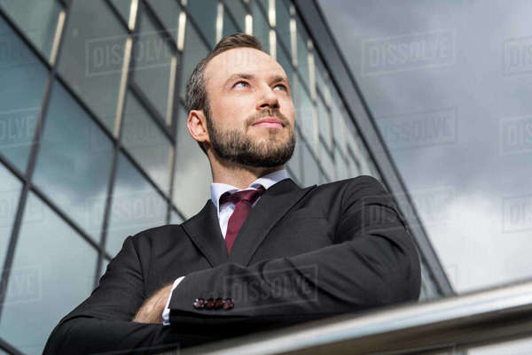 portrait of successful handsome businessman standing at office building ...