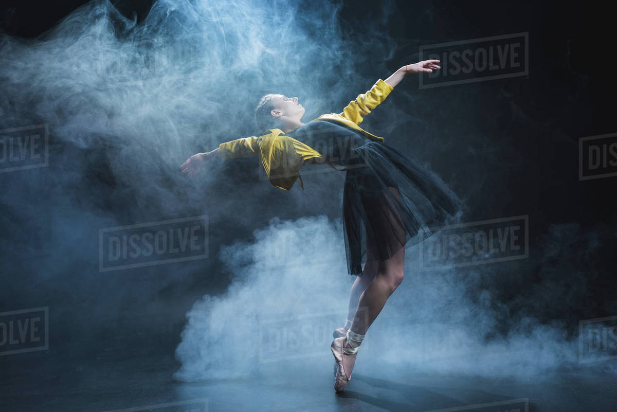 Elegant girl dancing in pointe shoes and black tutu and yellow leather ...