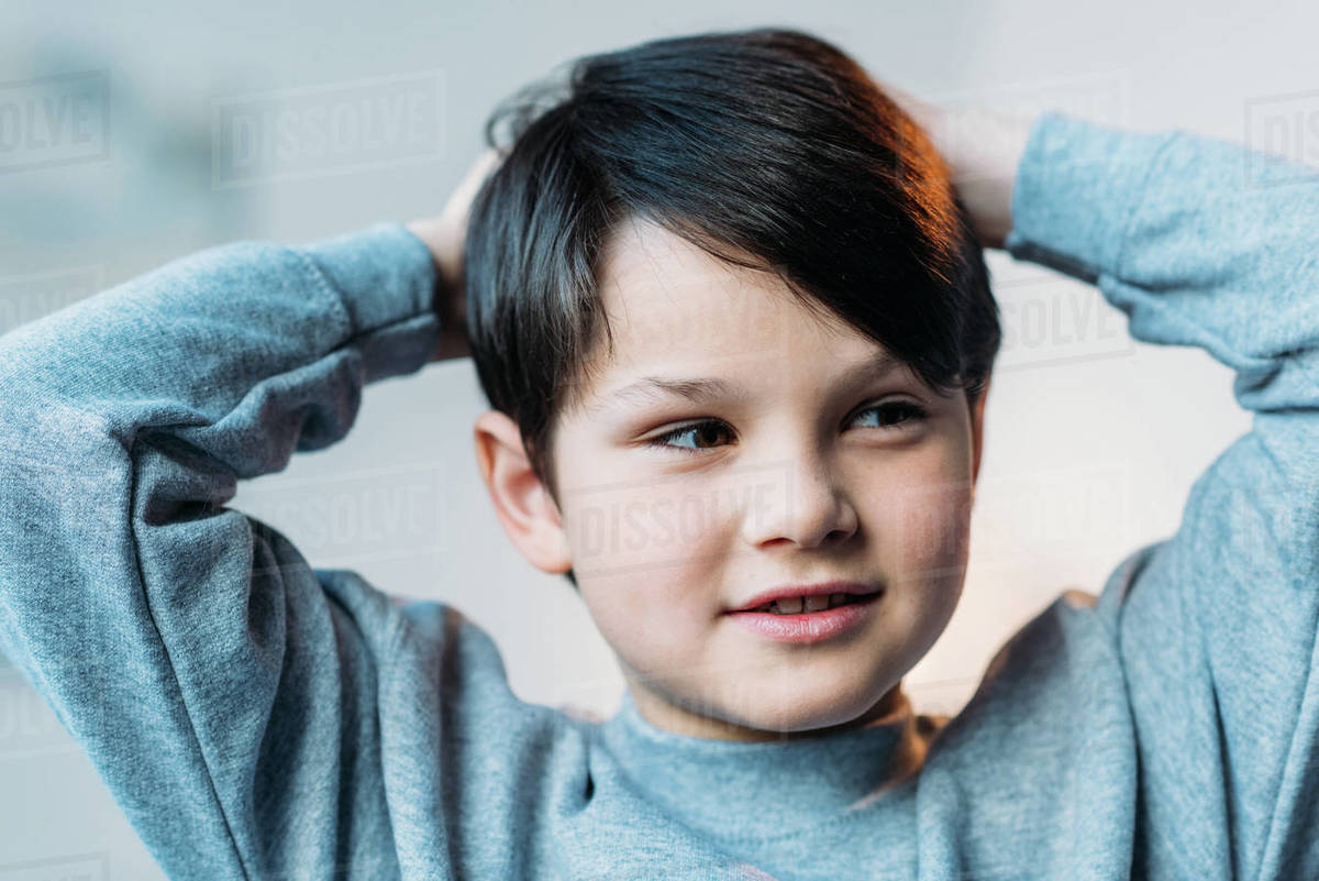 Portrait of little happy boy smiling with hands on head at home ...