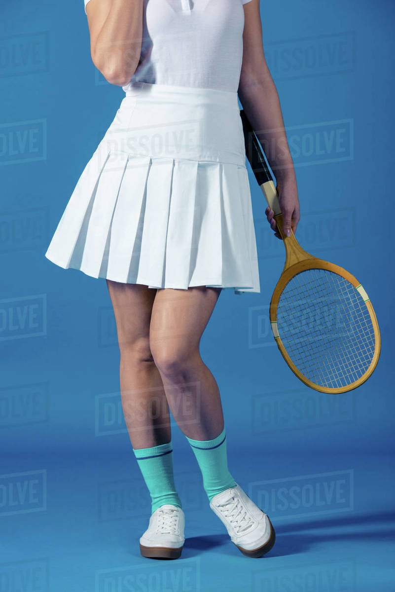 Cropped image of female tennis player standing with tennis racket on ...