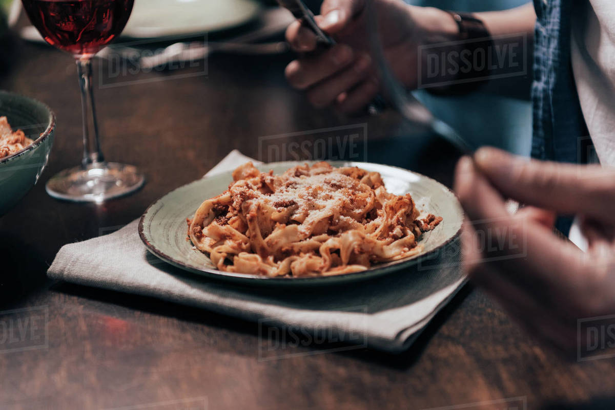 Cropped shot of person holding cutlery and eating tasty dinner - Stock ...